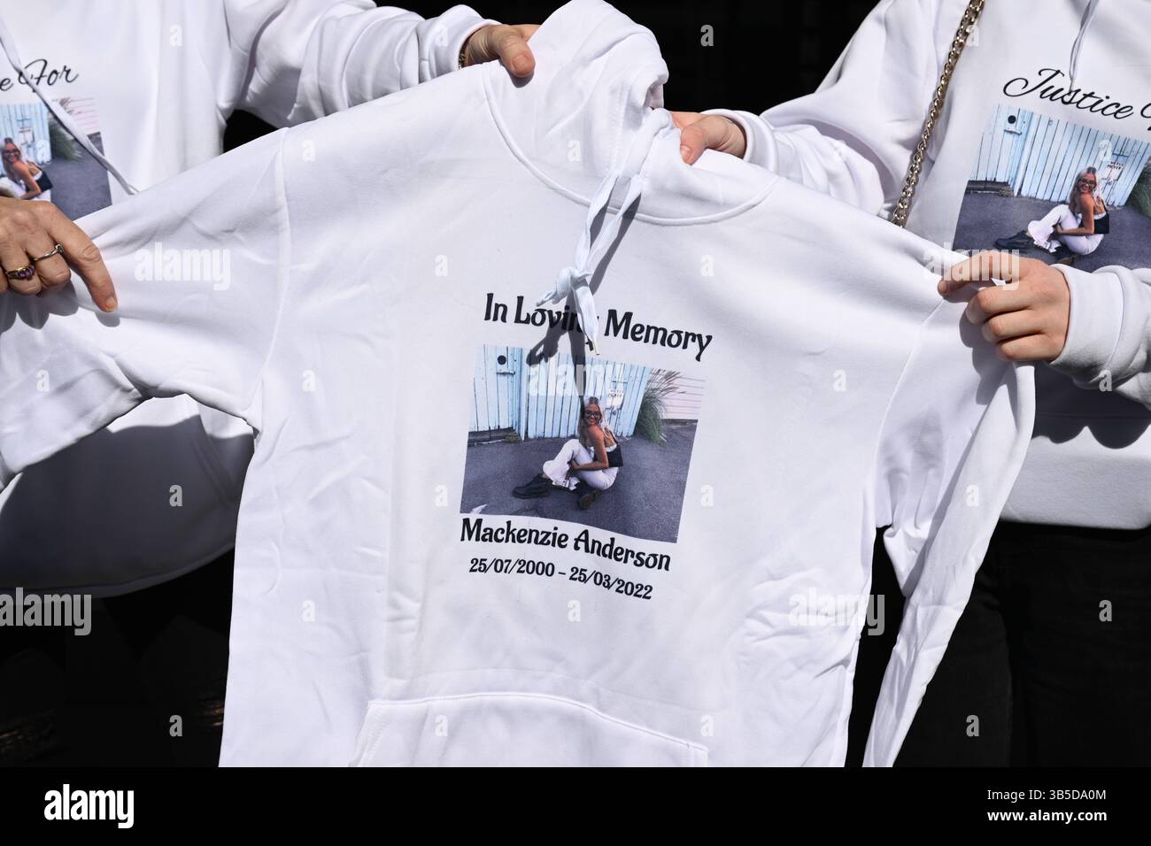 Friends of Mackenzie Anderson hold clothing memorialising her, outside ...