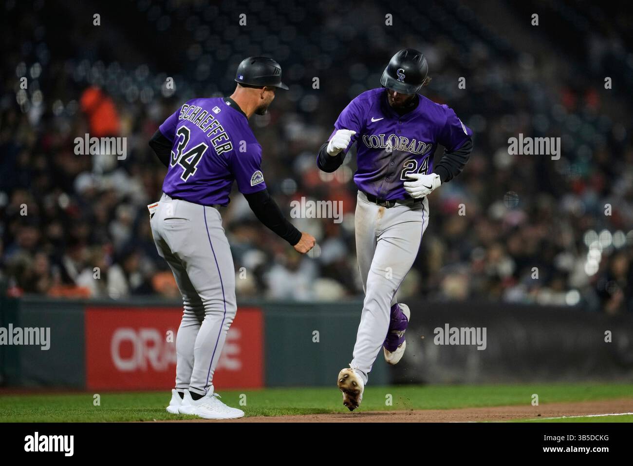Colorado Rockies' Ryan McMahon (24) celebrates with third base coach ...