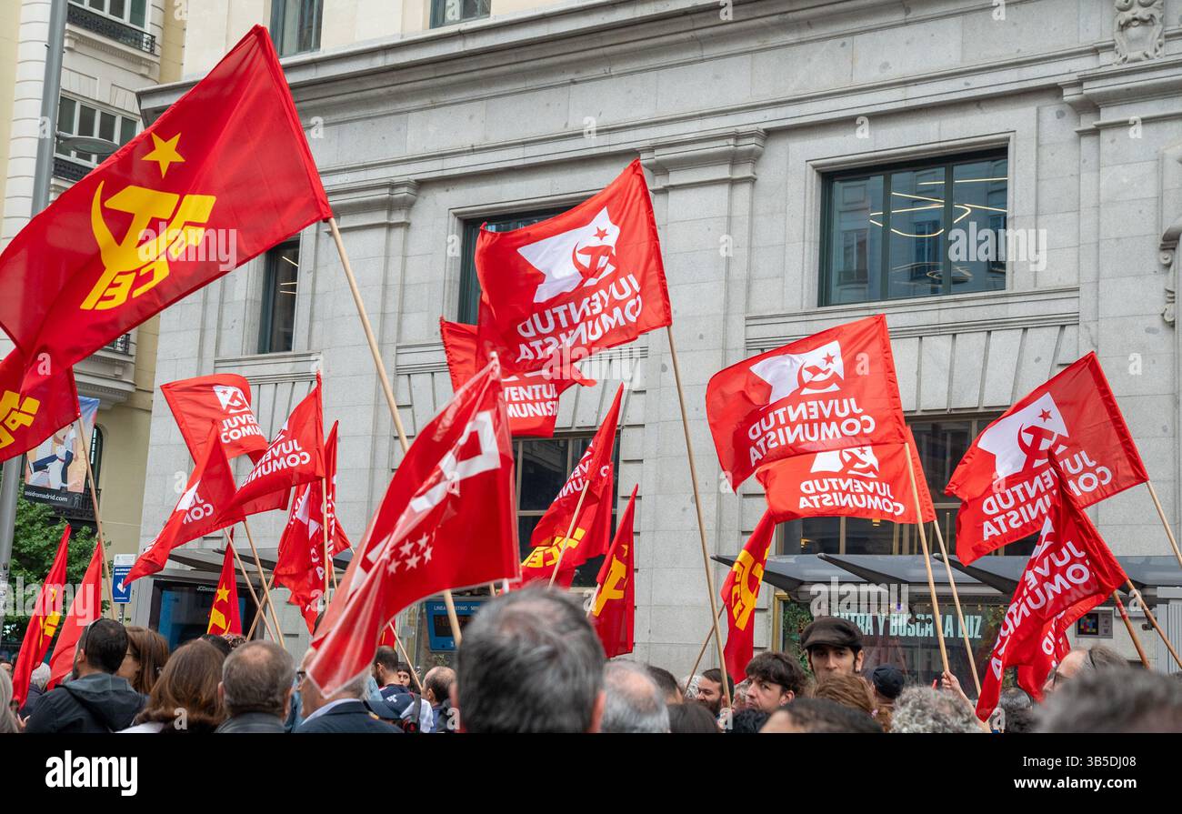 A vibrant group of demonstrators raise red flags representing the ...