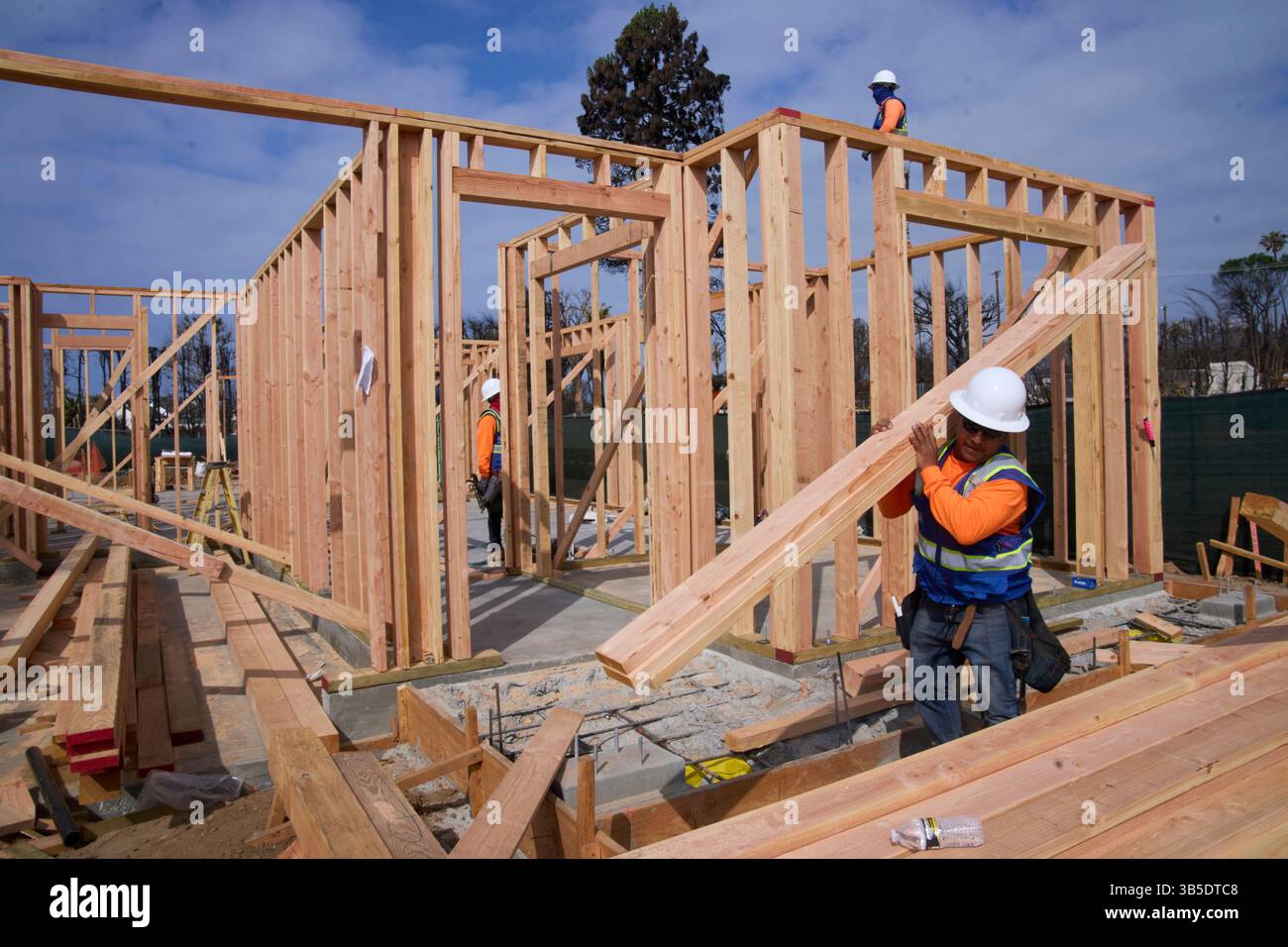 Workers rebuild a property destroyed by the Palisades Fire in the ...