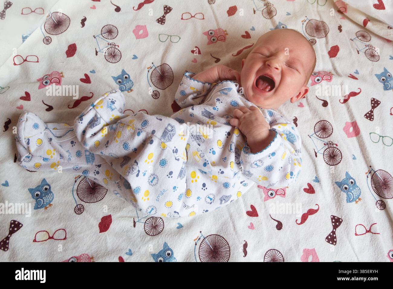A newborn baby screams and cries on the bed. People Stock Photo - Alamy