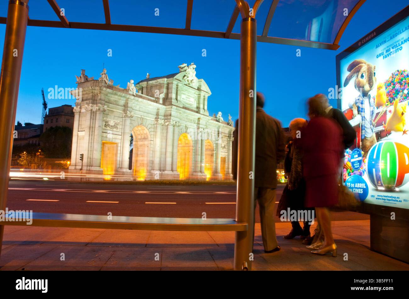 People at the bus stop, night view. Independencia Square, Madrid, Spain ...