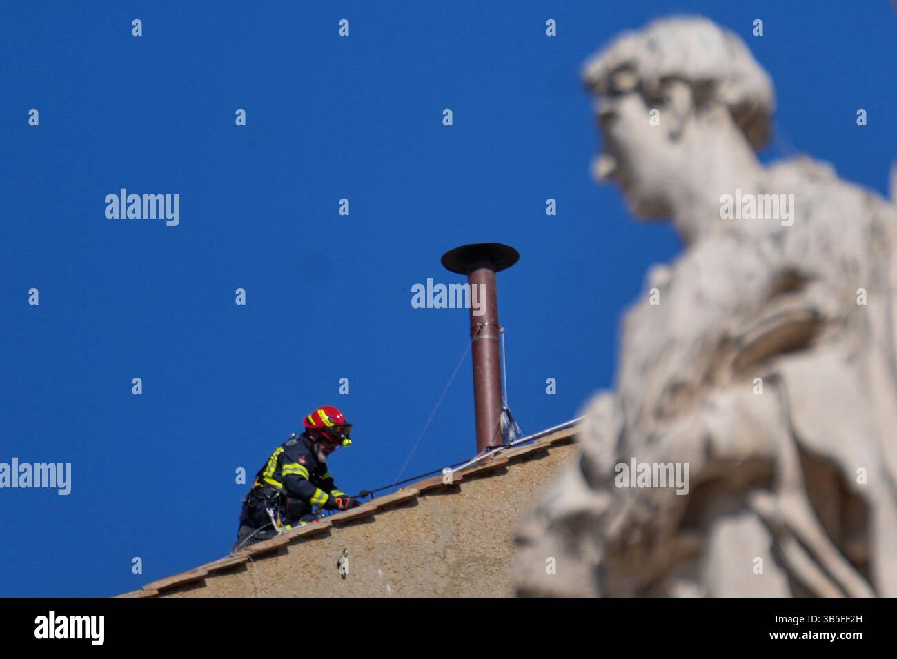 Firefighters place the chimney on the roof of the Sistine Chapel, where ...