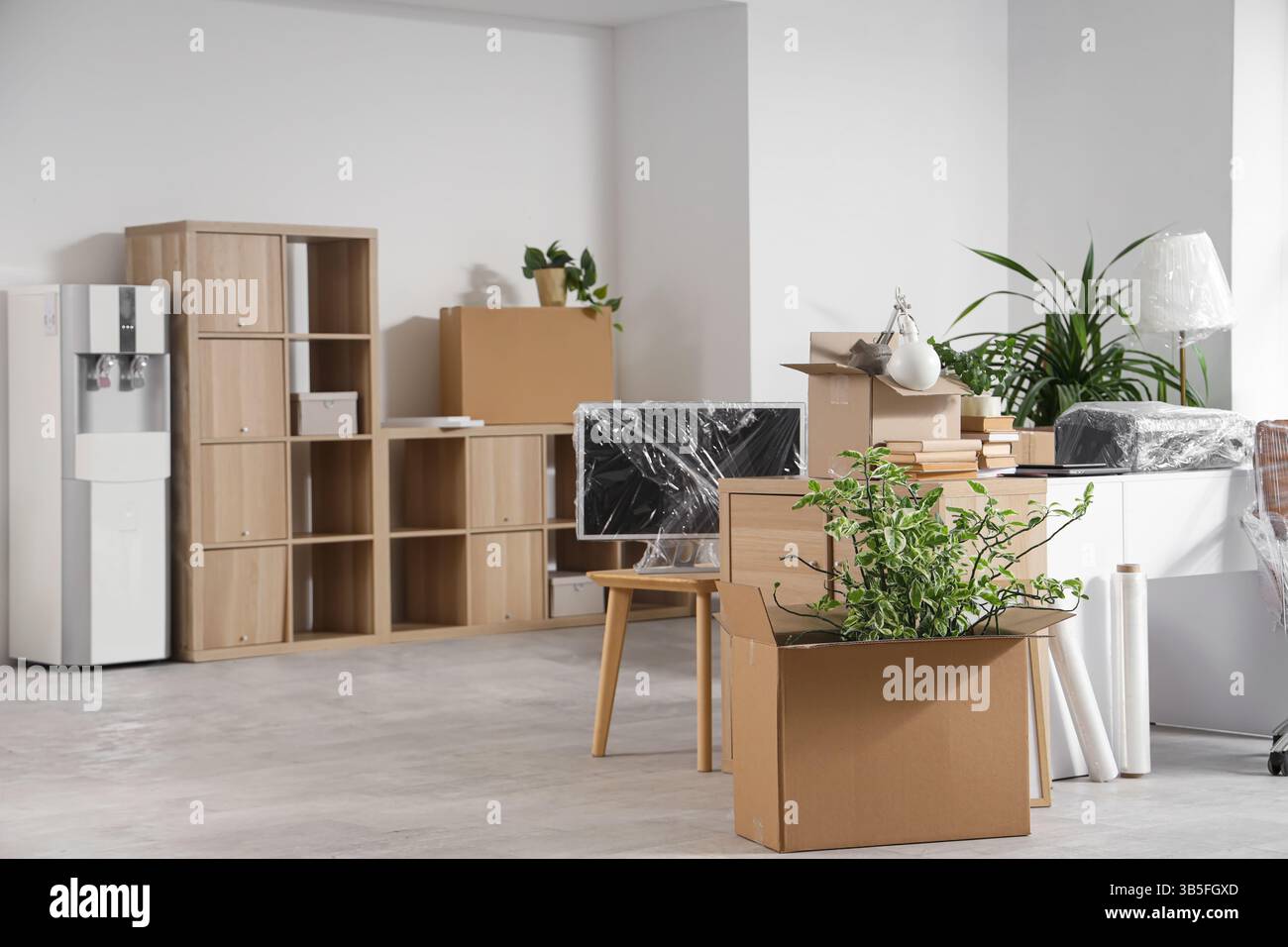 Interior of office with desk, boxes and wrapped monitor in stretch film ...