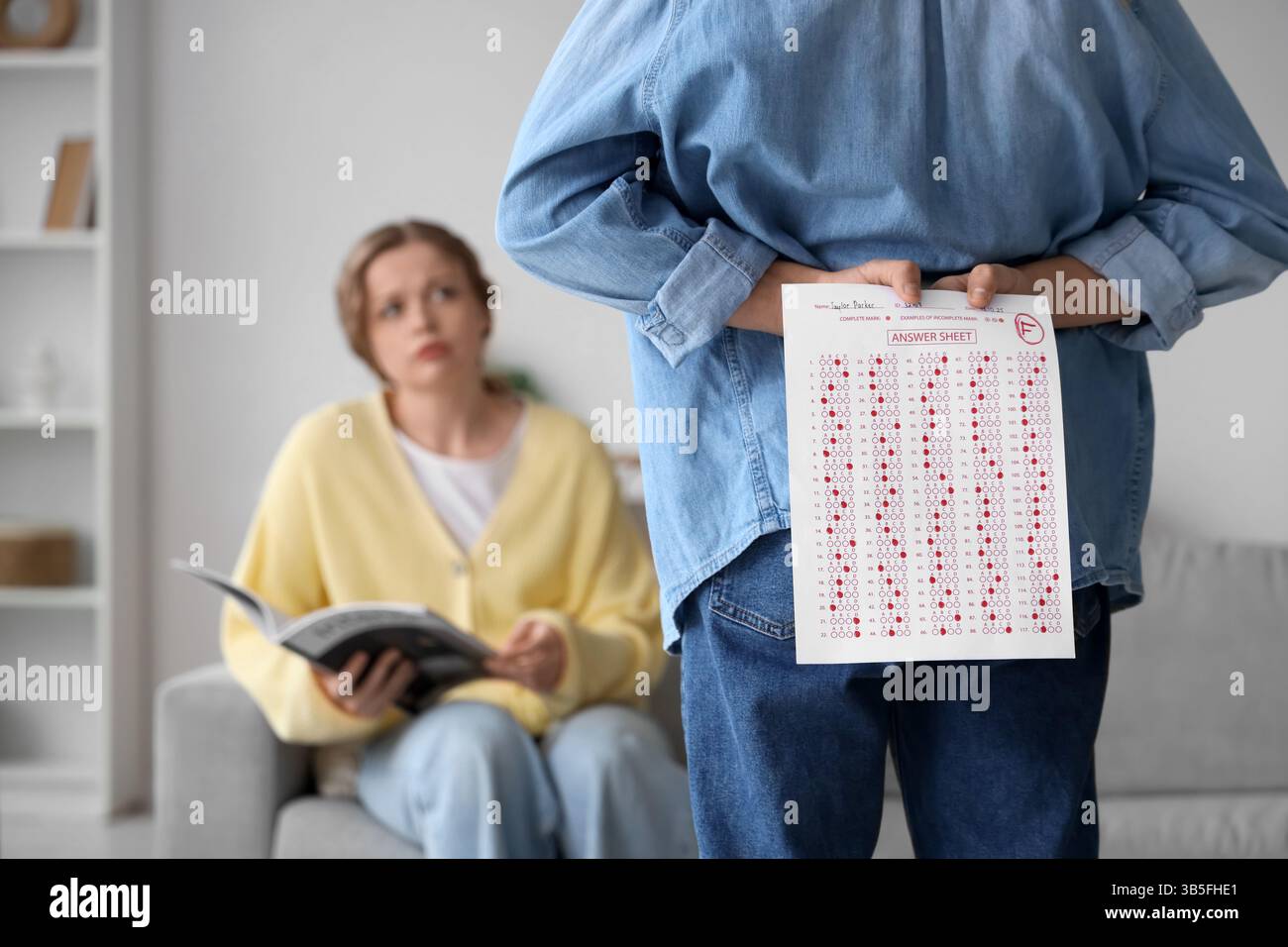Teenage boy hiding answer sheet for school test with bad grade from his ...