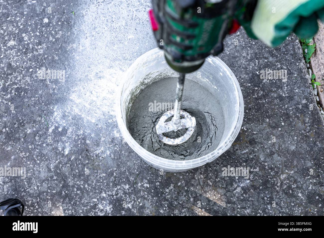 Mixing glue and mortar for gluing tiles on a terrace, container and ...