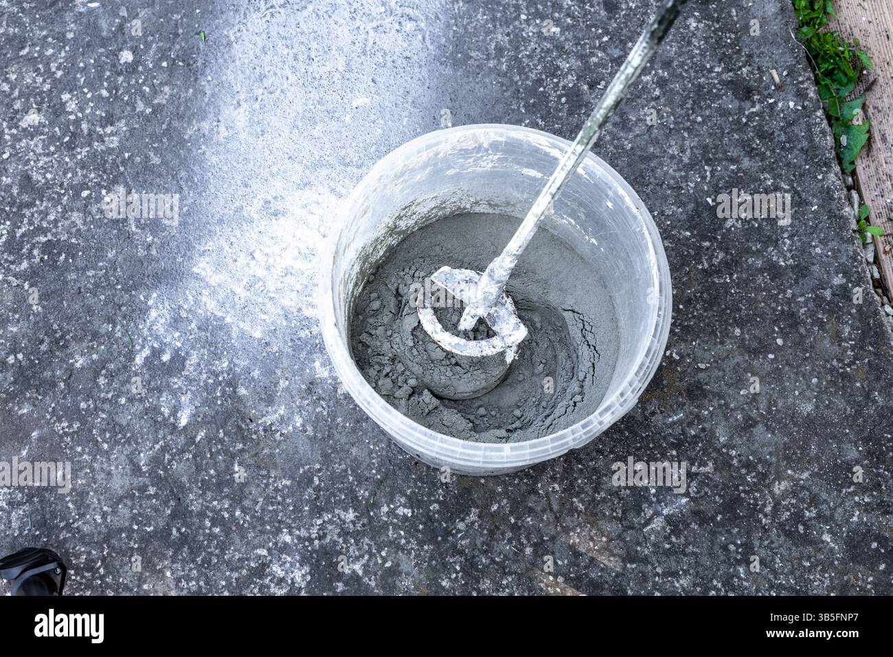 Mixing glue and mortar for gluing tiles on a terrace, container and ...