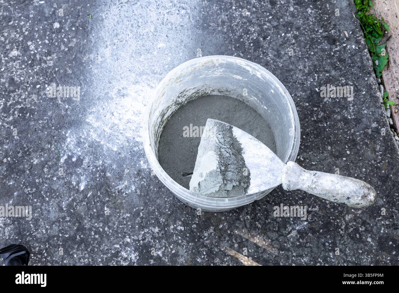 Mixing glue and mortar for gluing tiles on a terrace, container and ...