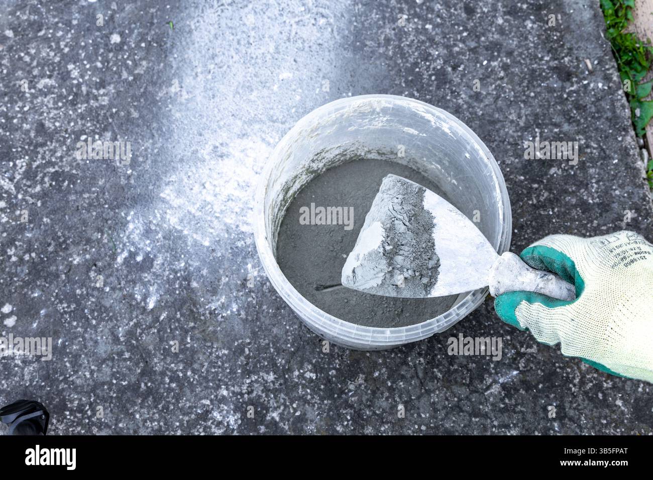 Mixing glue and mortar for gluing tiles on a terrace, container and ...