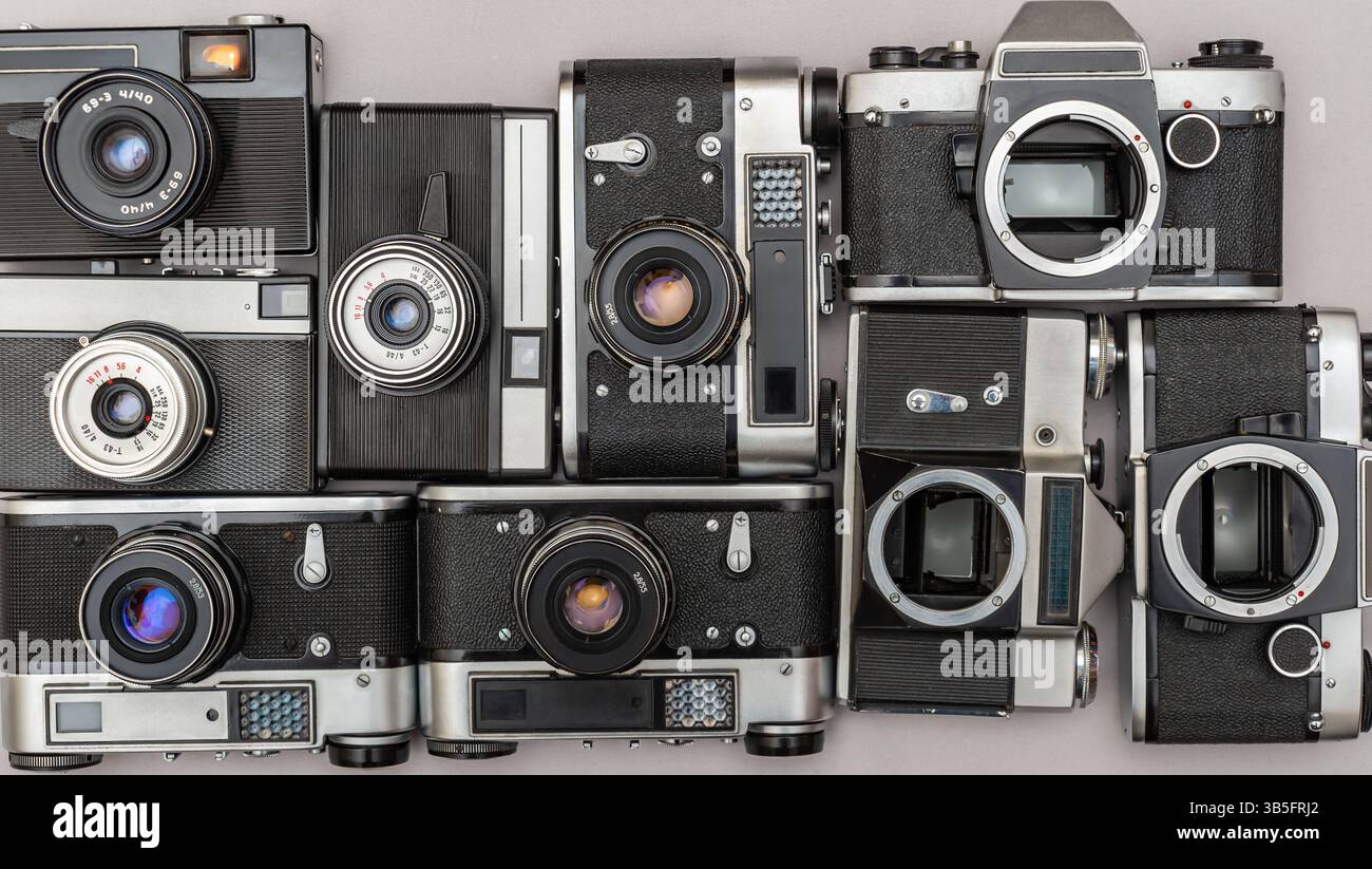 A diverse assortment of old film cameras displayed together ...