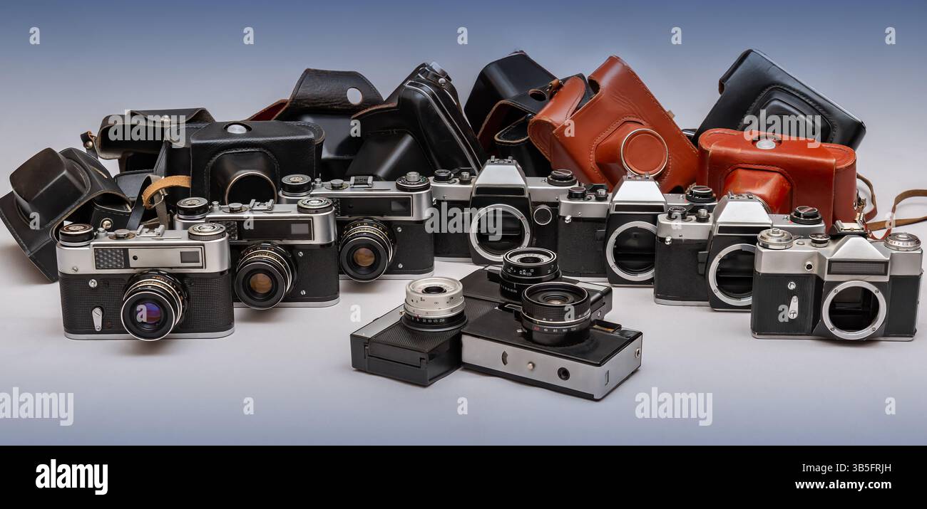 Collection of various used film cameras and leather cases illustrates ...