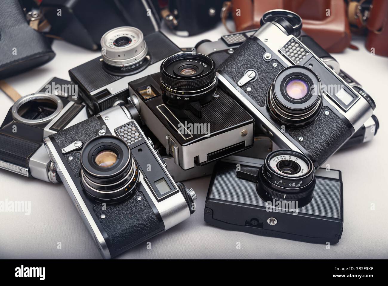 A diverse assortment of old film cameras displayed together ...