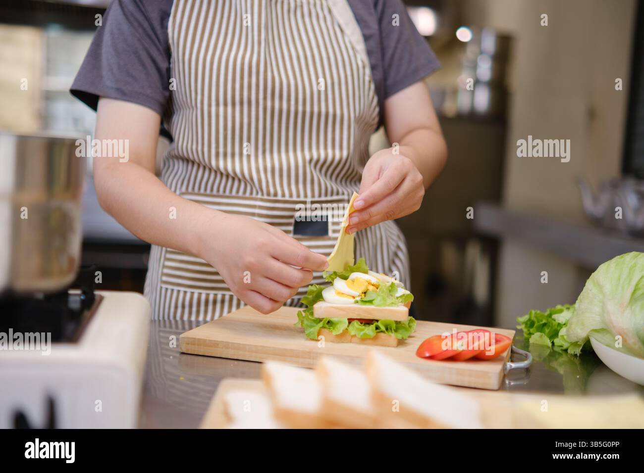 Chef adding cheese slice to a fresh sandwich Stock Photo - Alamy