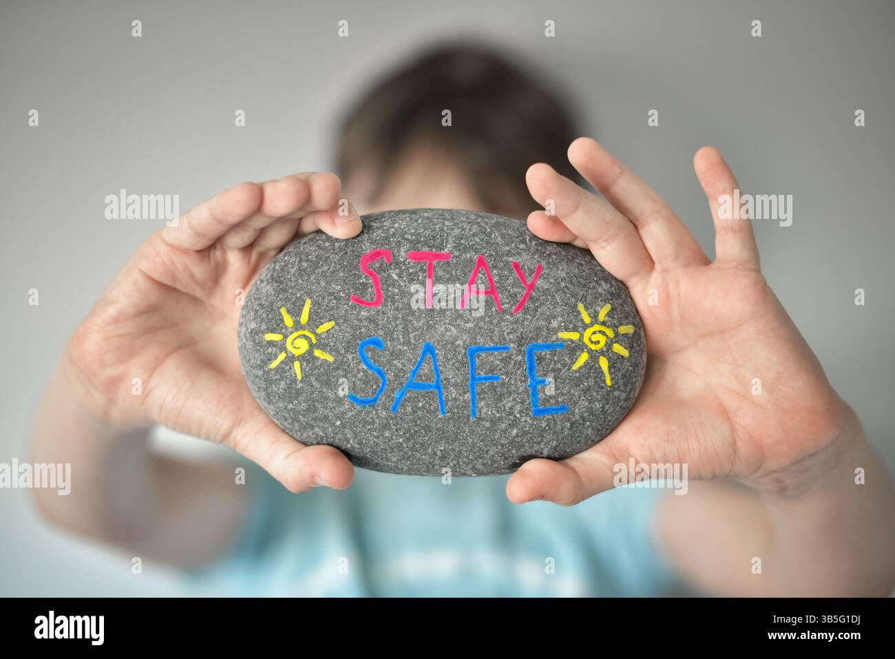 Child holding stone stay safe Stock Photo - Alamy