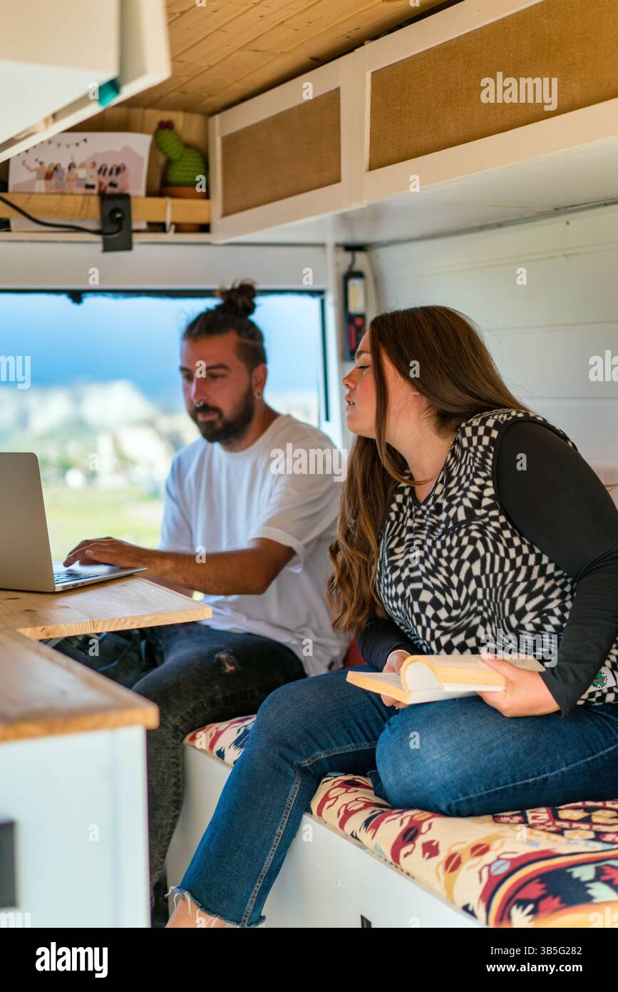 Digital nomad couple enjoying van life in camper van Stock Photo - Alamy