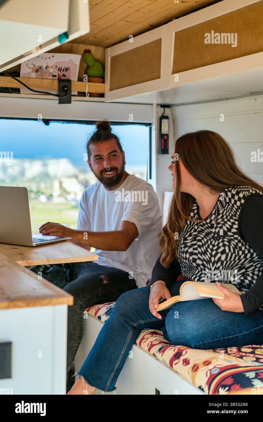 Digital nomad couple enjoying van life in camper van Stock Photo - Alamy