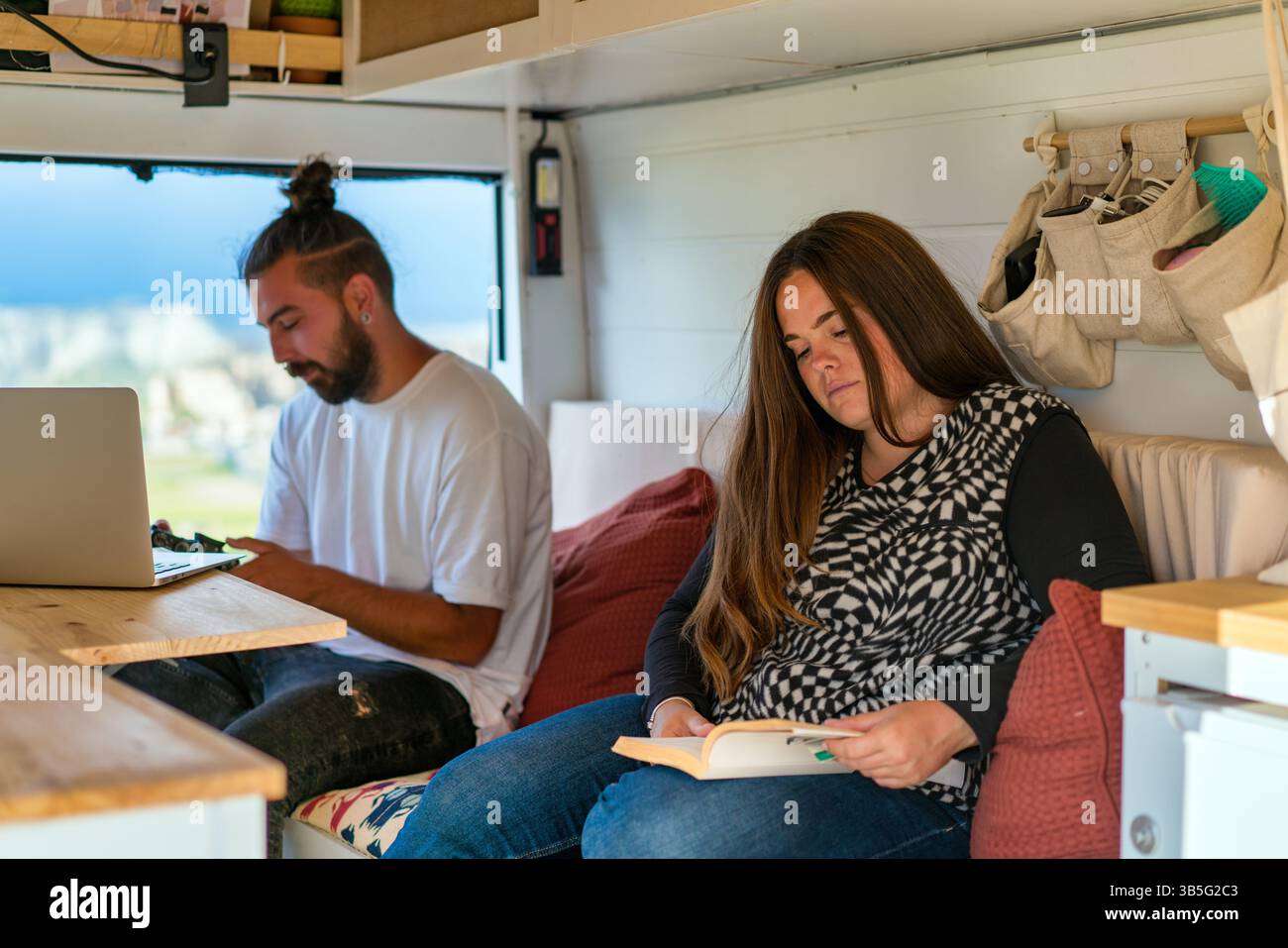 Digital nomad couple enjoying van life in camper van Stock Photo - Alamy