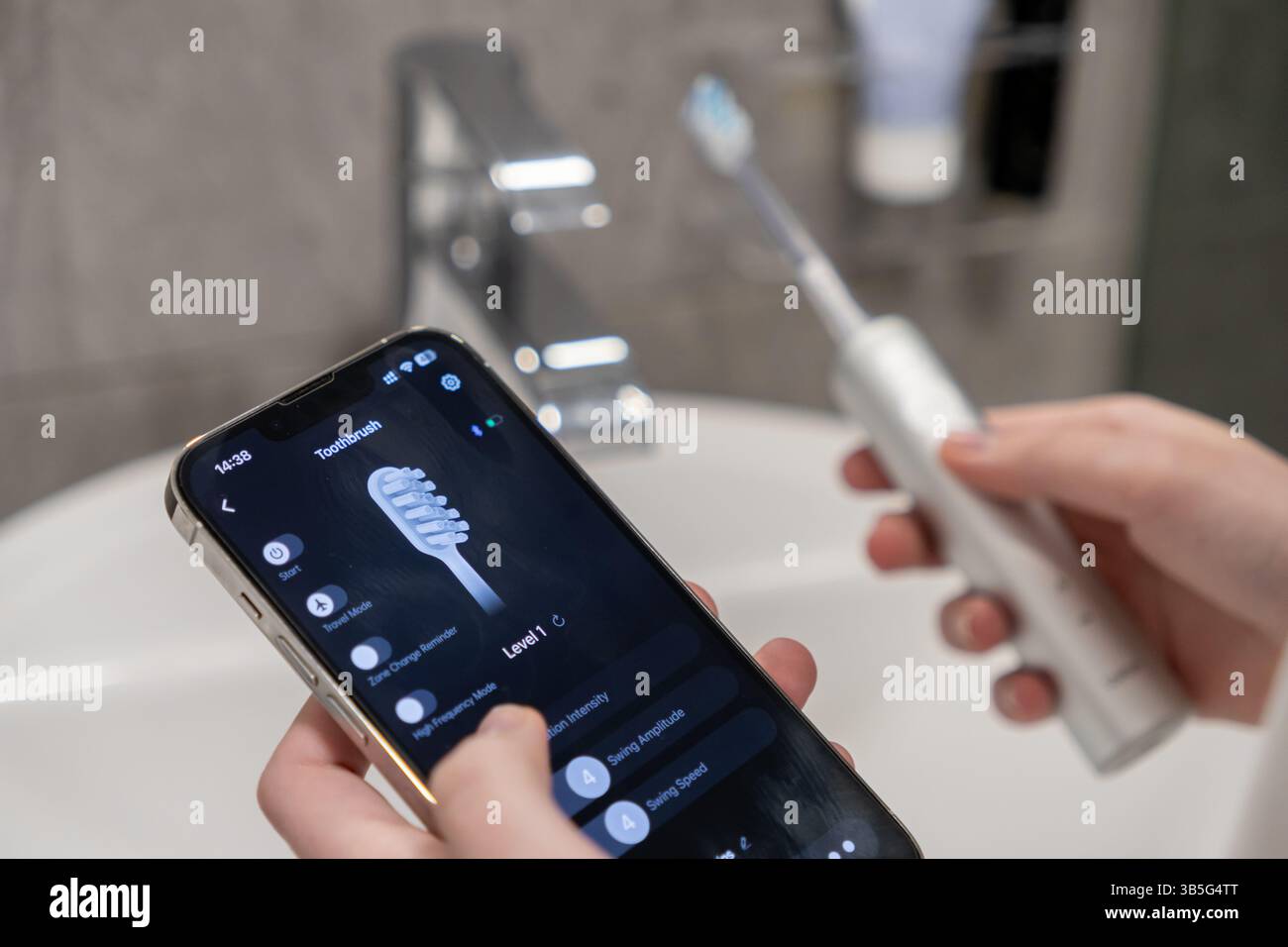 With a smartphone app interface visible on screen, hands demonstrate ...