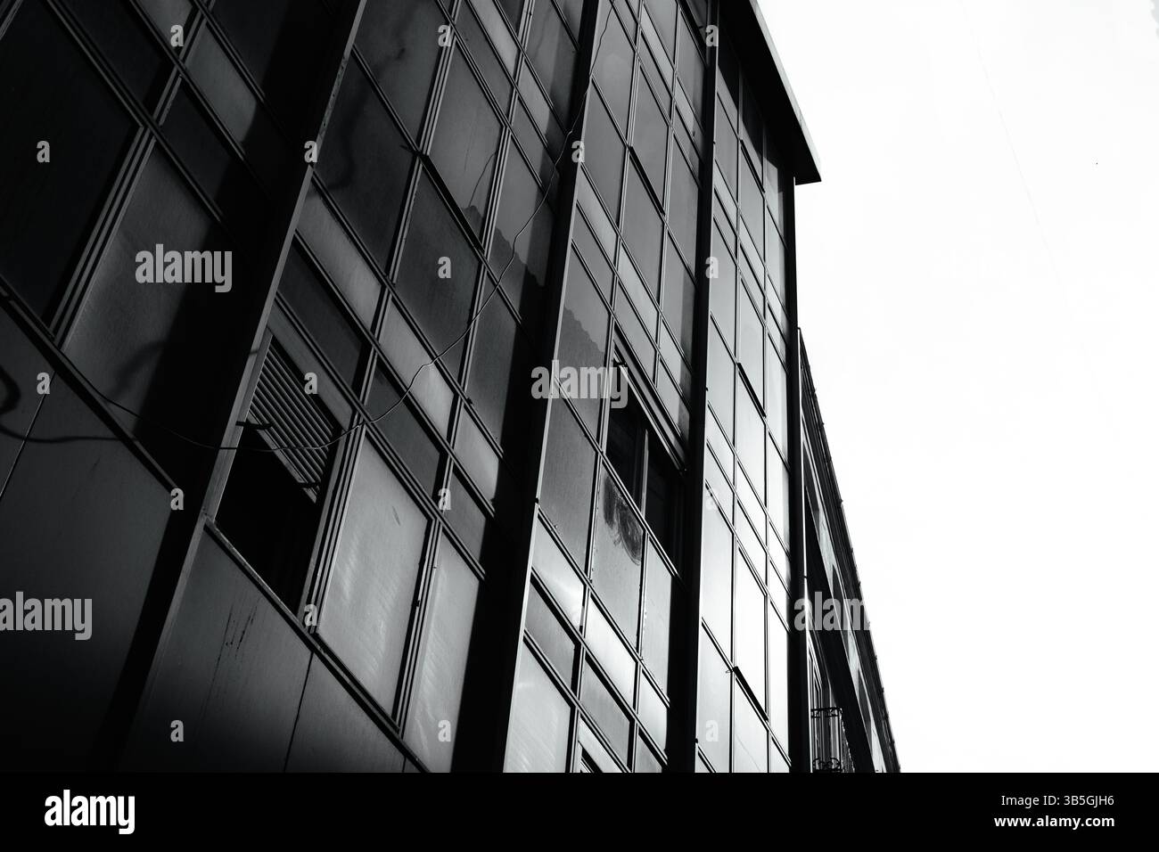 A modern office building illuminated from sun rays on moody day. Rows ...