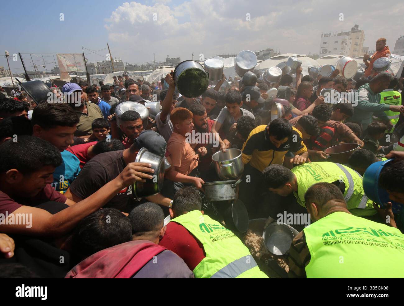 Long queues formed during the distribution of food by an aid ...