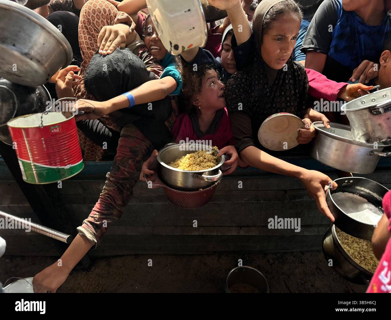 Long queues formed during the distribution of food by an aid ...