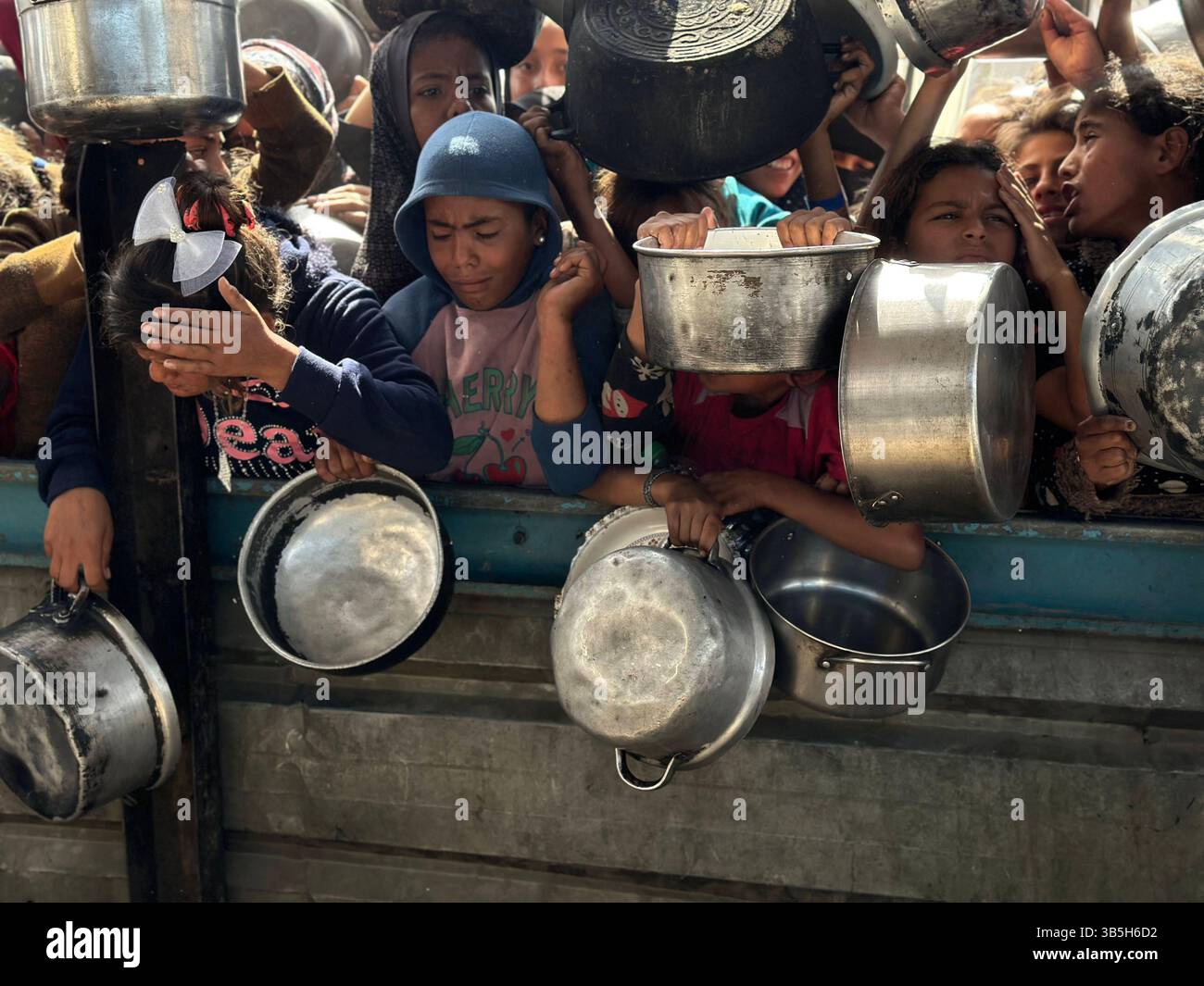 Long queues formed during the distribution of food by an aid ...