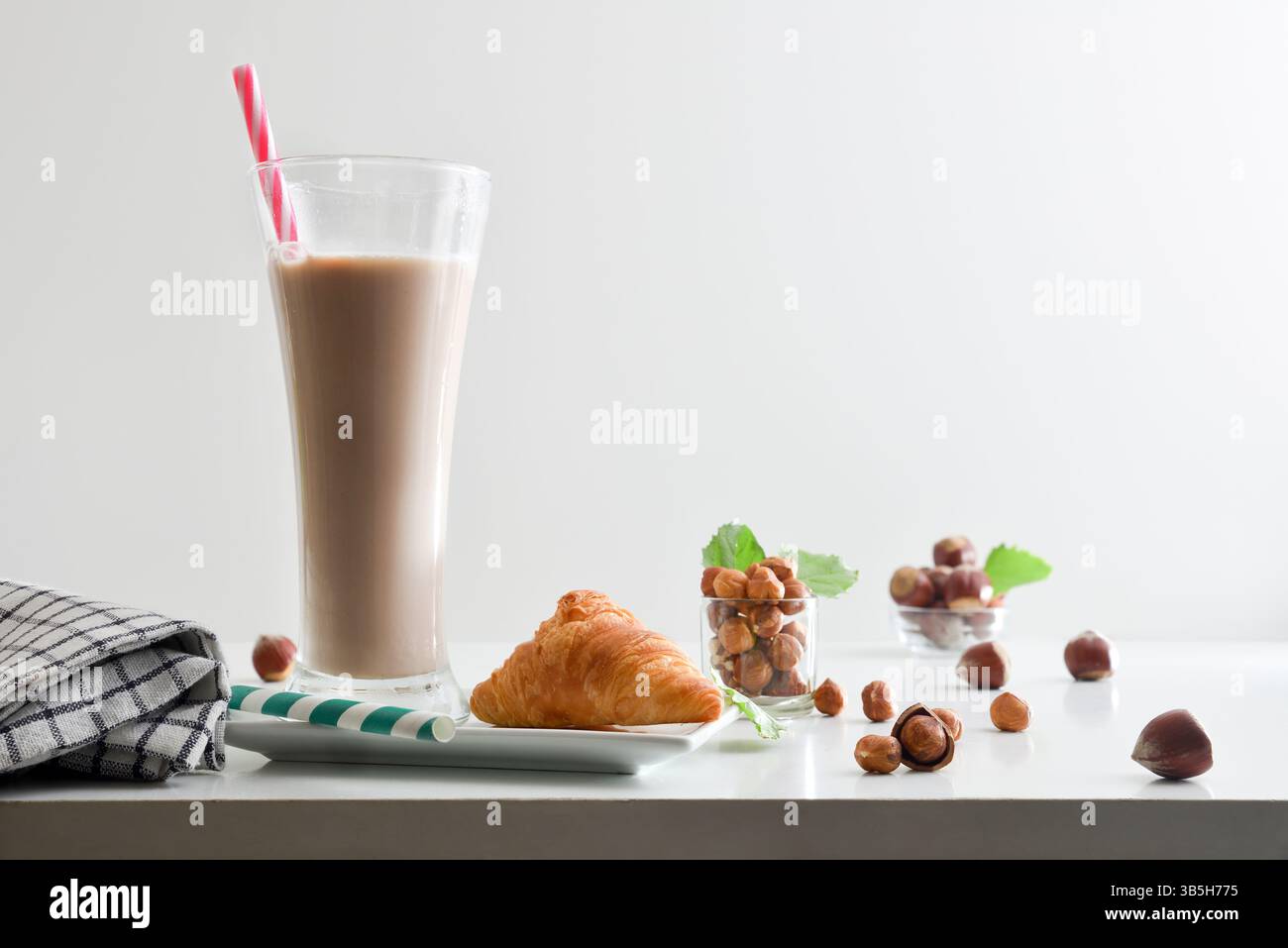 Snack on white bench with glass of hazelnut drink and bowls full of ...