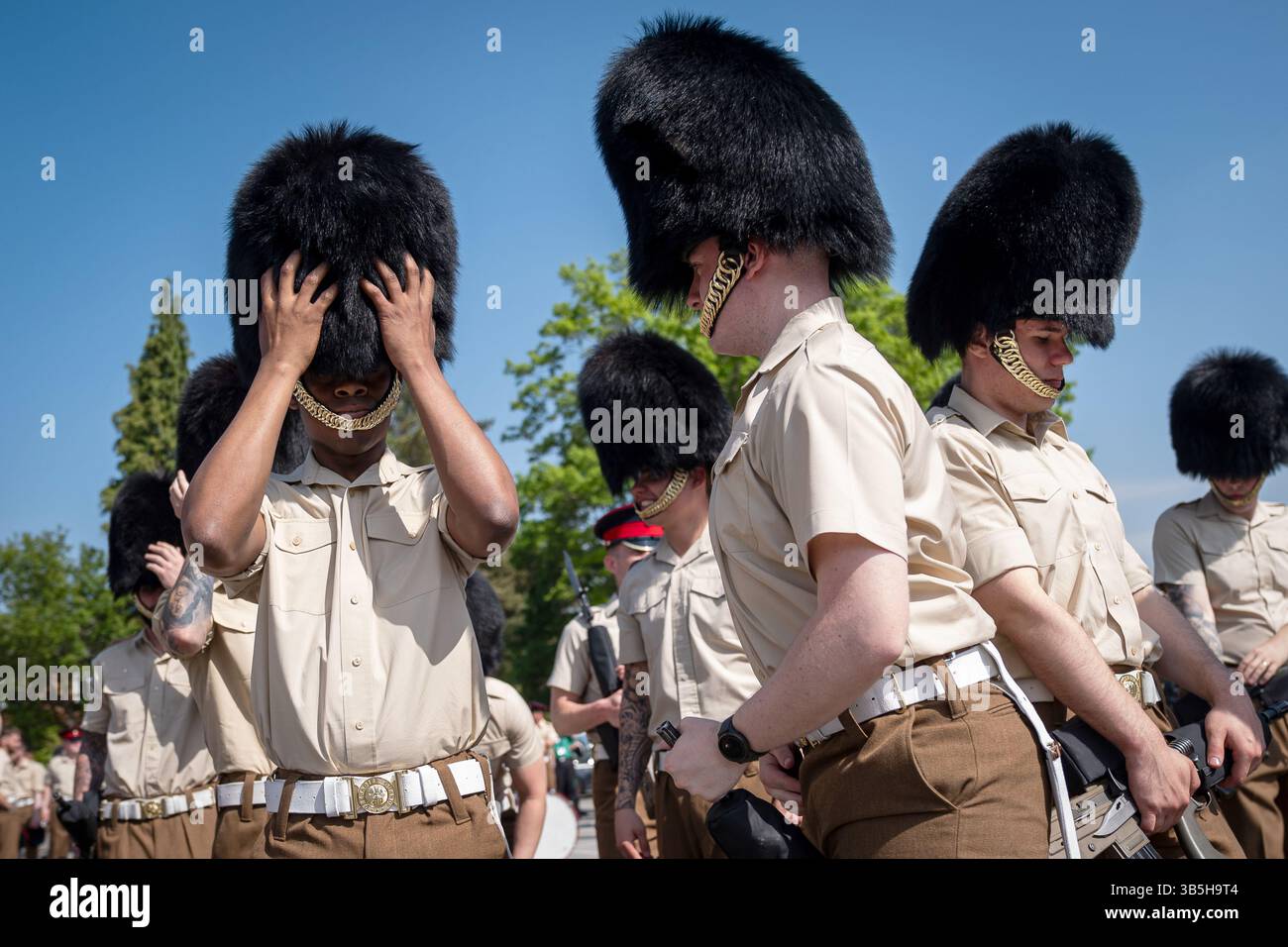 Members of the Armed Forces put on their bearskin hats, during a ...