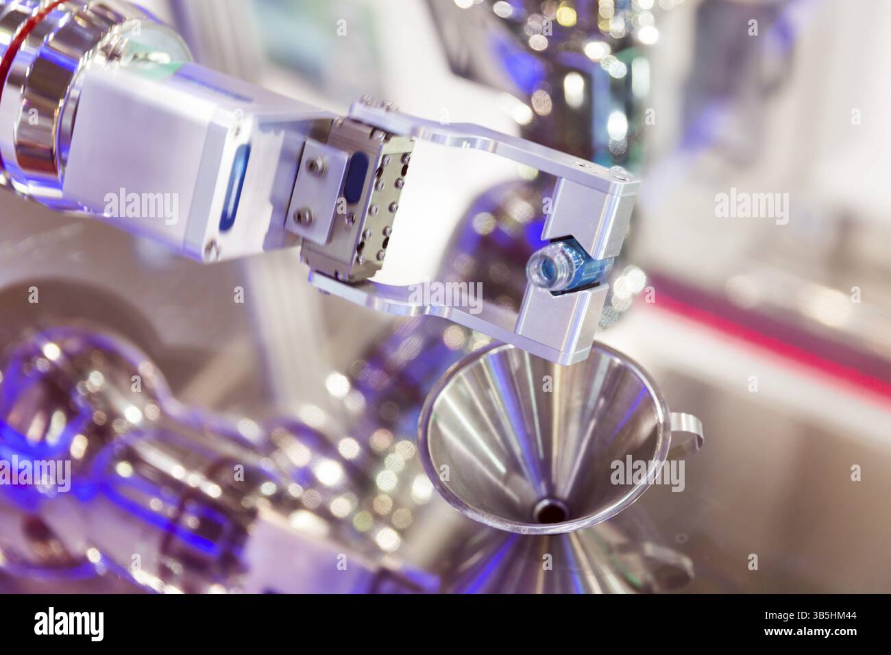 Robotic mechanical arm is pouring chemical tubes full with blue ...