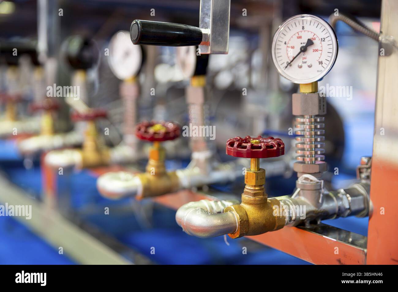 Pressure measuring instrument - bar, psi. Red metal valves on the pipes ...