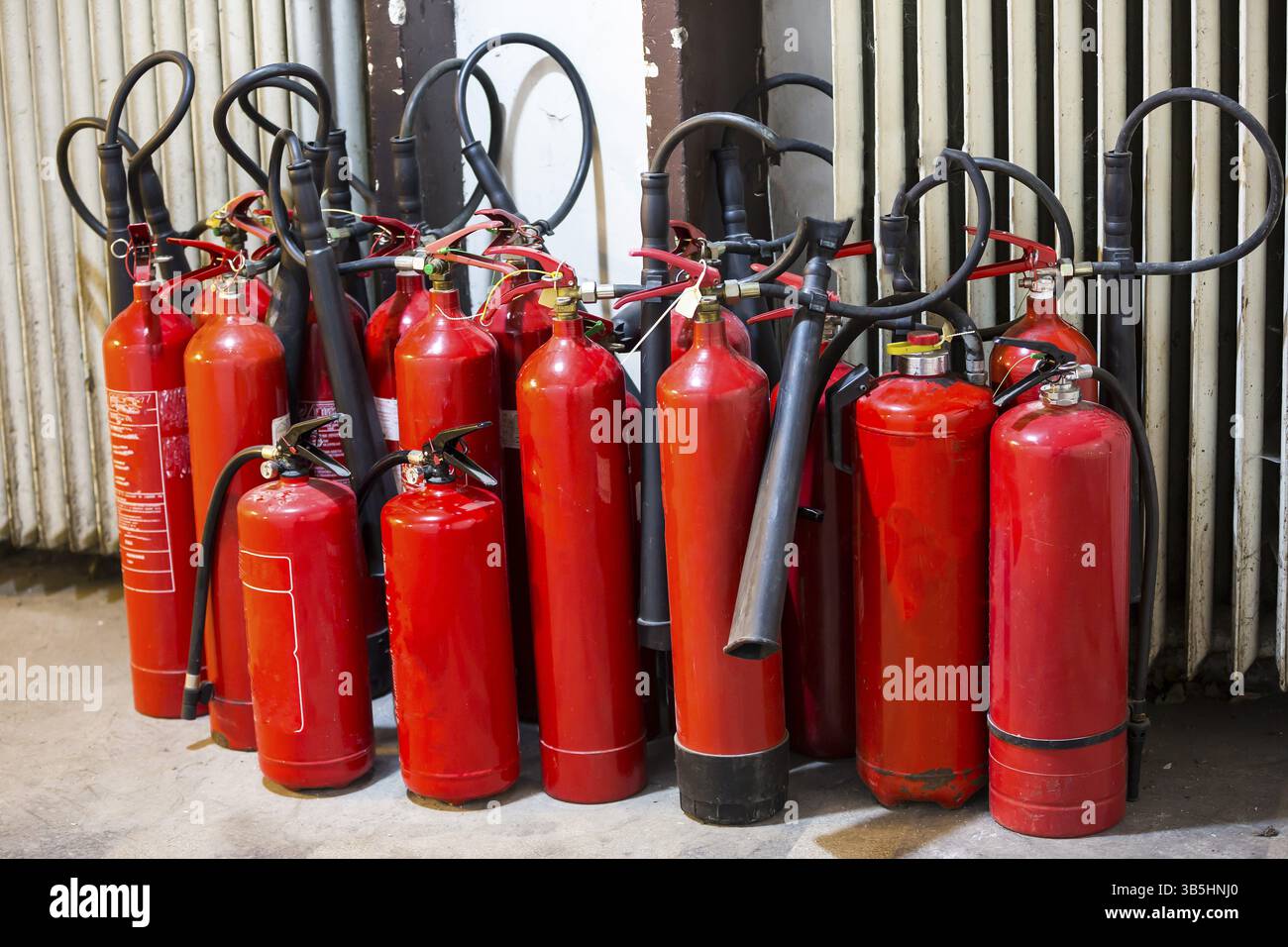 Many red fire extinguishers on the ground. Foam, Carbon dioxide, Powder ...