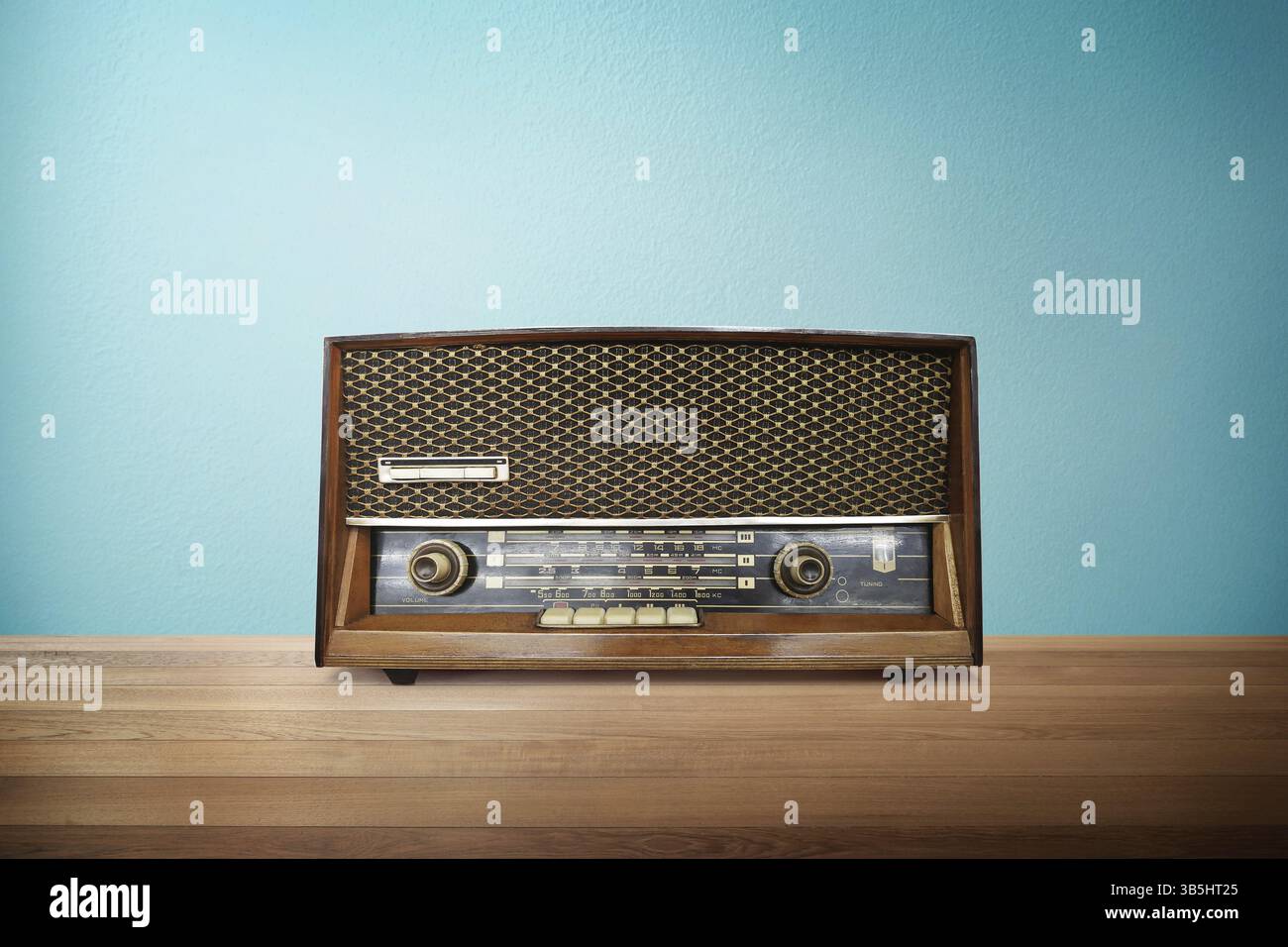 Old vintage retro broadcast radio on wood table with mint blue ...