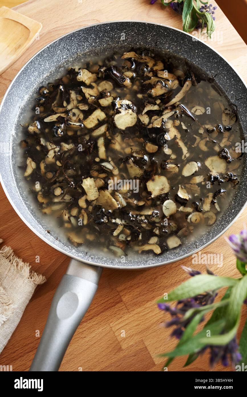 Home preparation of comfrey root ointment using rendered pork lard in a ...