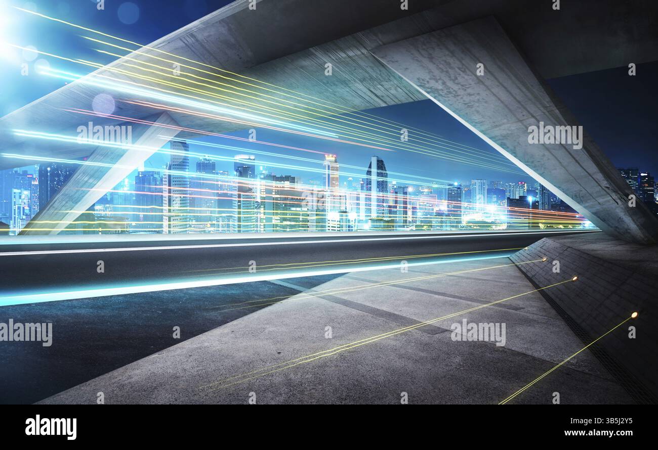 Empty asphalt road under the bridge during the night with light trails ...