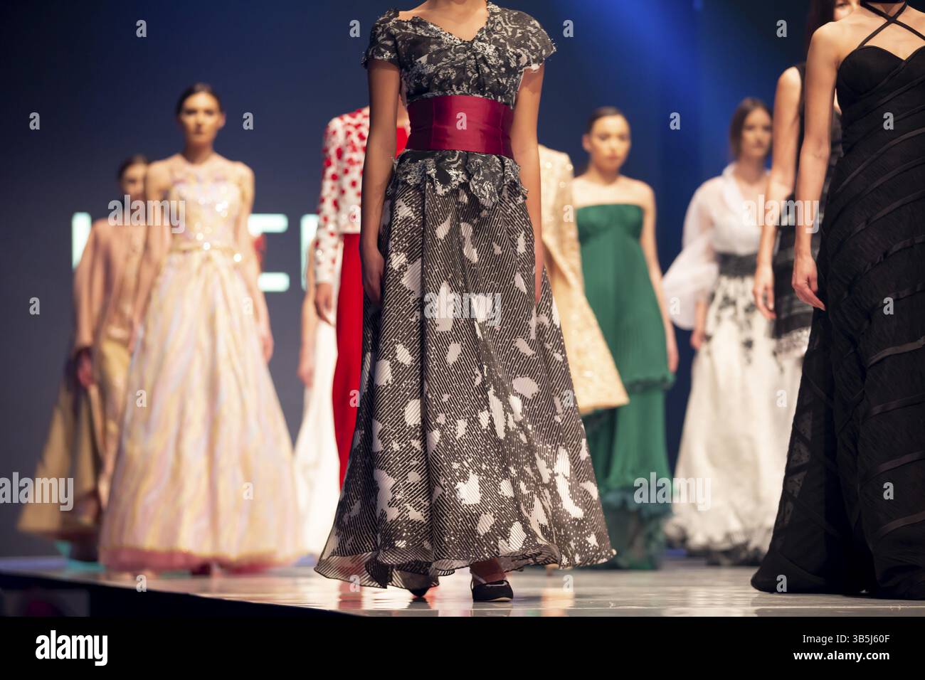 Female models walk the runway in beautiful colorful dresses during a ...