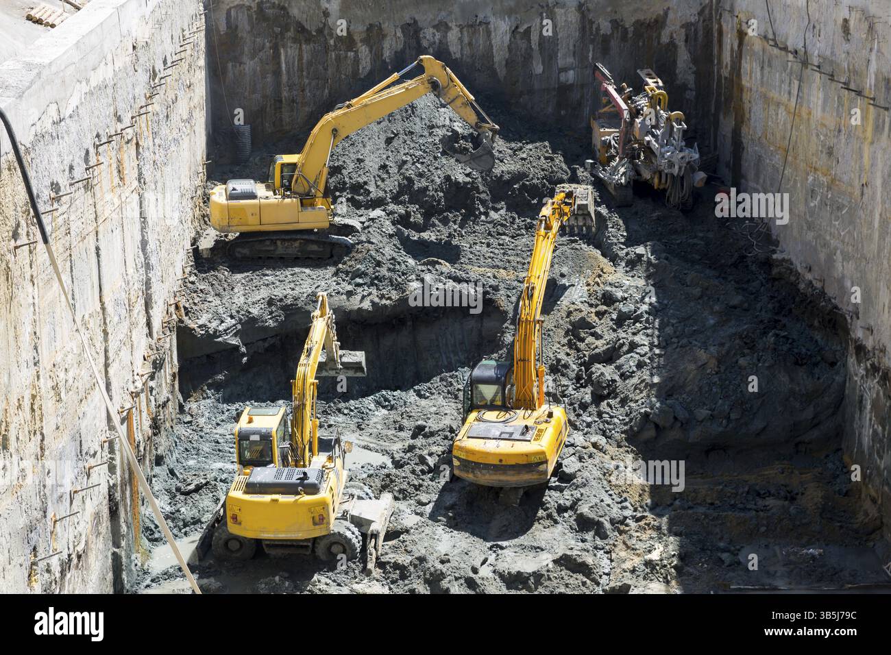 Excavators dig at a construction site of a street and a subway. Baggers ...