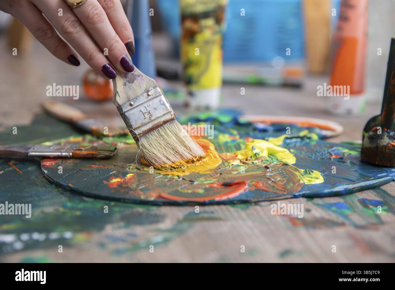 A detailed closeup of a hand skillfully mixing together vibrant and ...