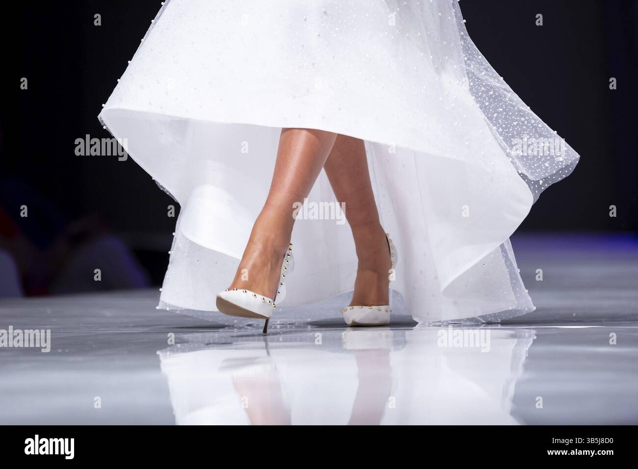 Female model walks the runway in white dress during a Fashion Show ...