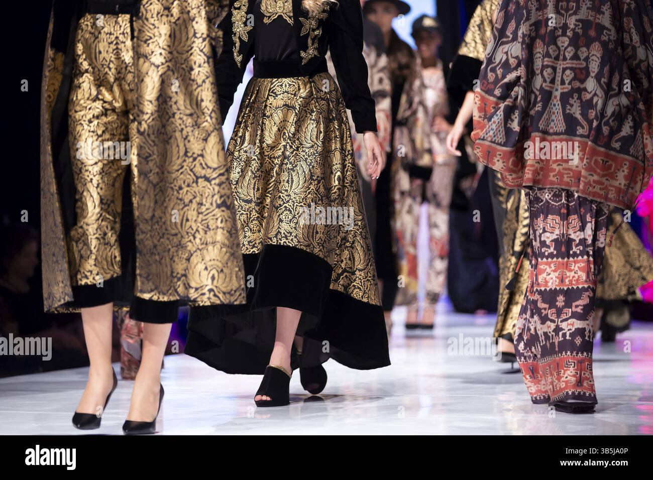 Female models walk the runway in different colorful dresses during a ...