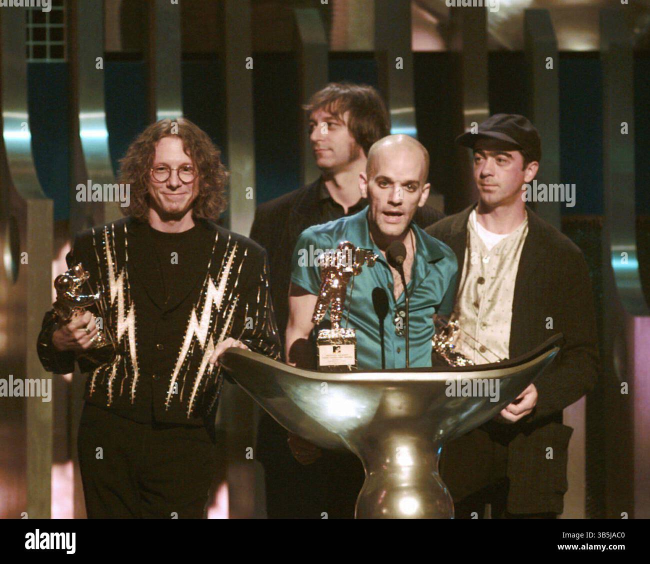 FILE - Michael Stipe, of the band R.E.M., center, speaks as he accepts ...