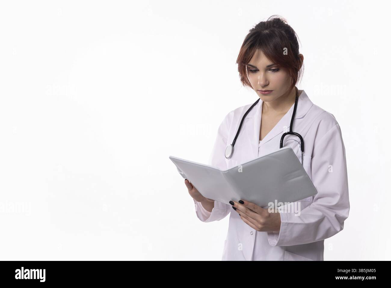 A female doctor in a lab coat reviews a medical folder, highlighting ...