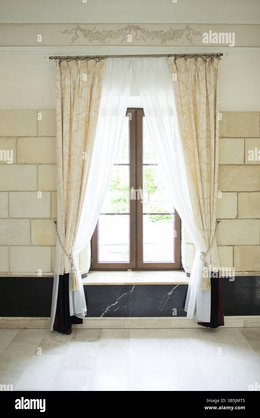 The interior richly decorated. Window with light curtains upraised on ...