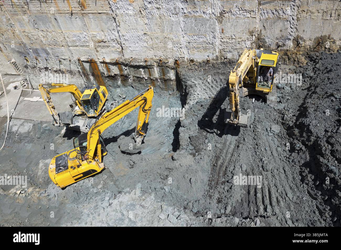 Excavators dig at a construction site of a street and a subway. Baggers ...