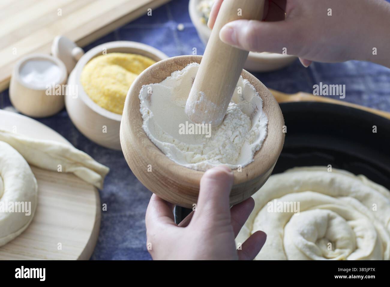 Female hand holding mortar and pestle with wheat flour All around ...