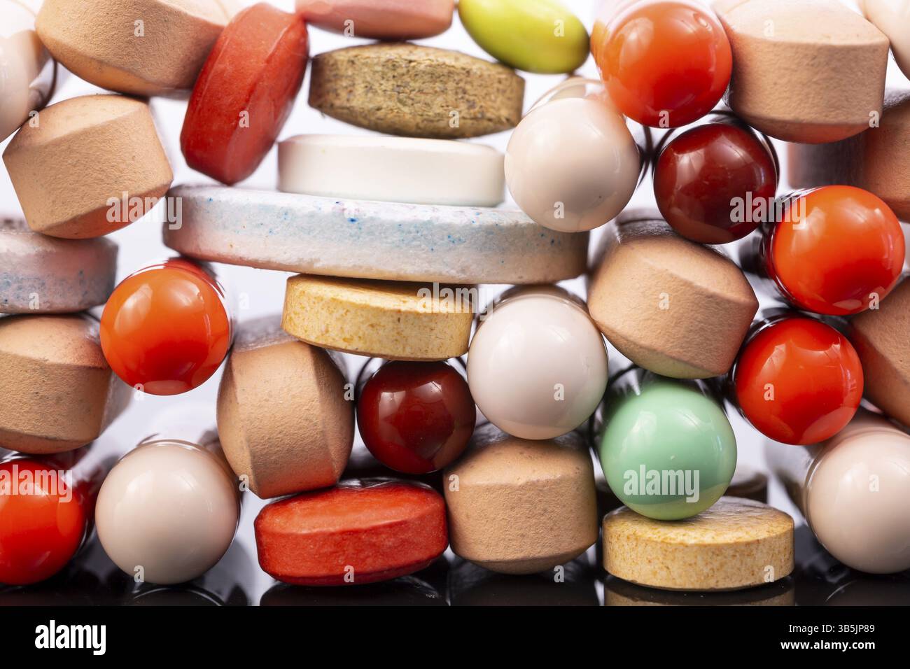 Different colorful pills and capsules stacked. Global pharmaceutical ...