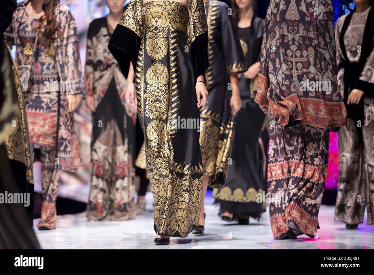 Female models walk the runway in different colorful dresses during a ...