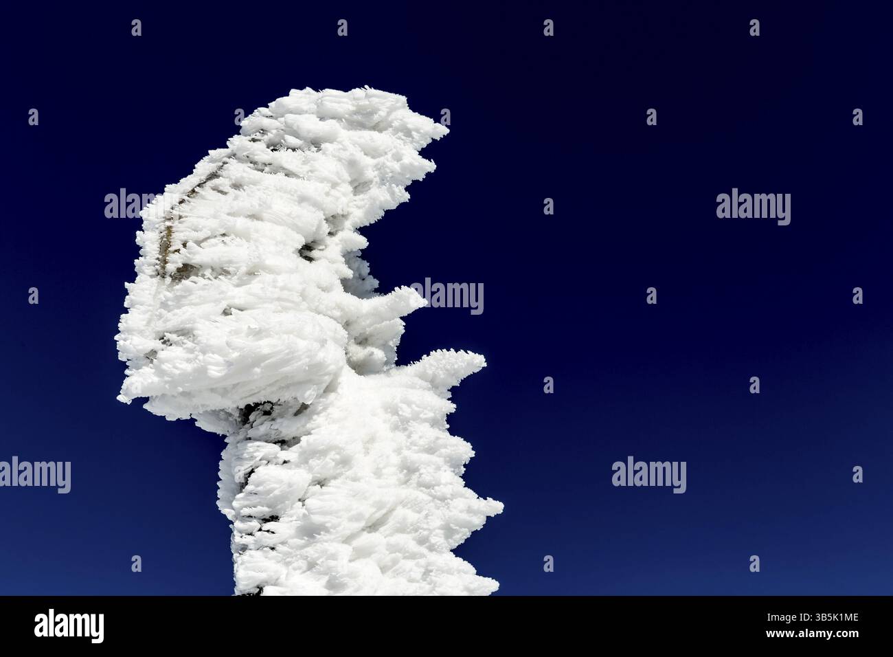 A frozen sign is seen high up in the mountain against the clean blue ...