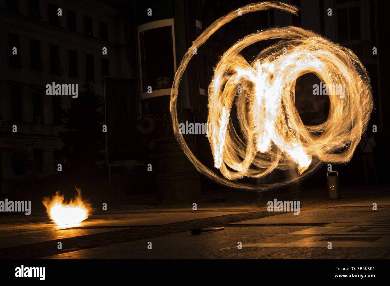 Performers are spinning torches while performing a fire show at night ...