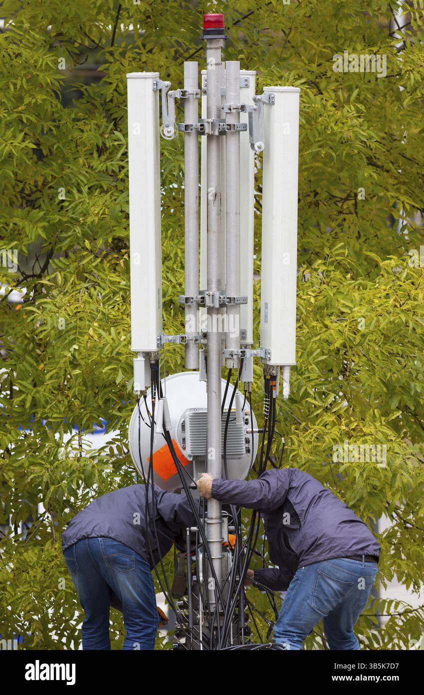 Workers repair a telecommunication (GSM) mobile antenna. GSM signal ...