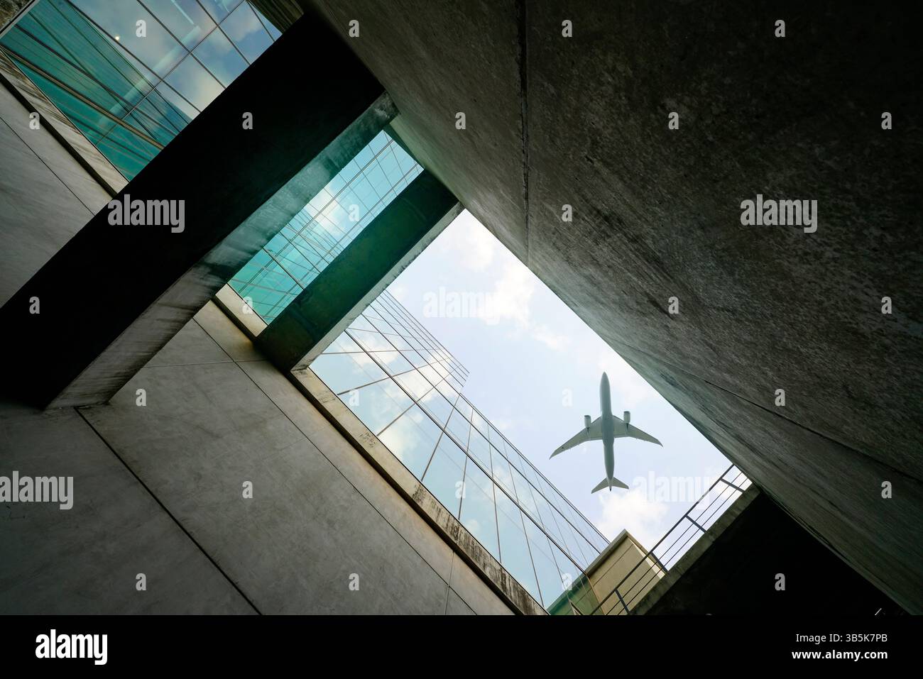 Commercial airplane flying above sustainable glass skyscraper. Cargo ...